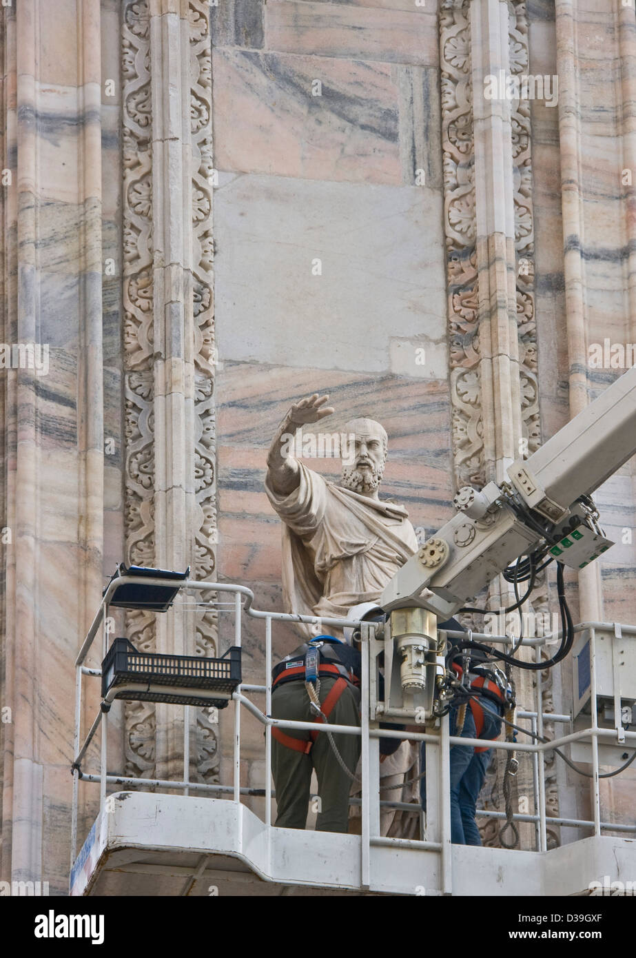 Workers on hydraulic platform restoring a statue sculpture artwork on ...
