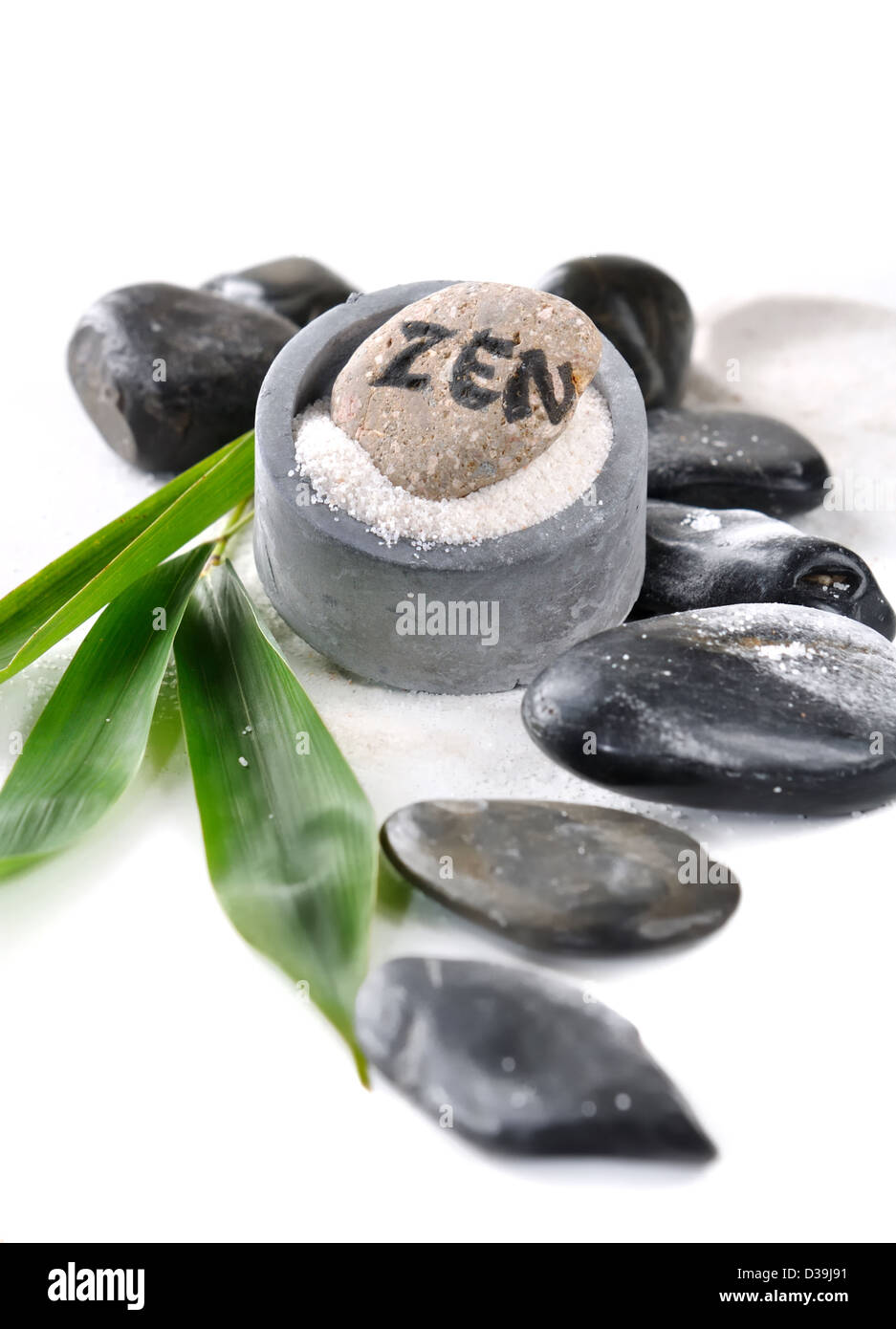 zen pebble in sand with balck pebbles and bamboo leaves on white ...