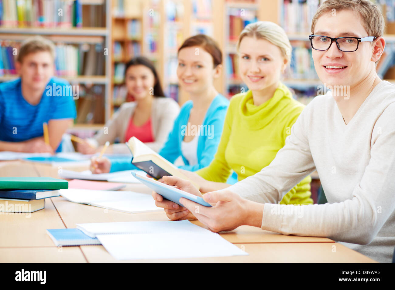 Portrait of group of students sitting in college library Stock Photo ...