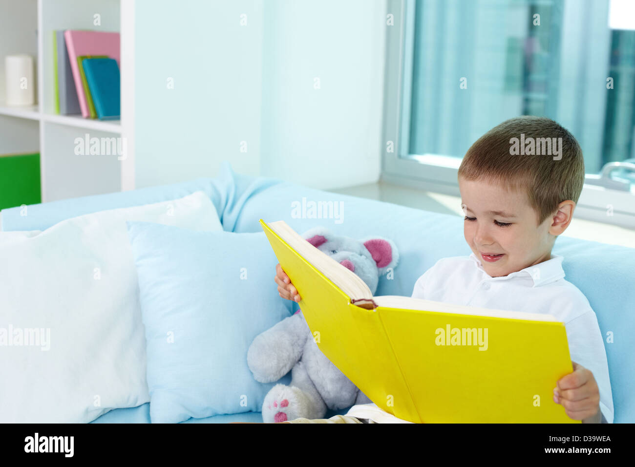 Boy reading interesting book at home Stock Photo - Alamy