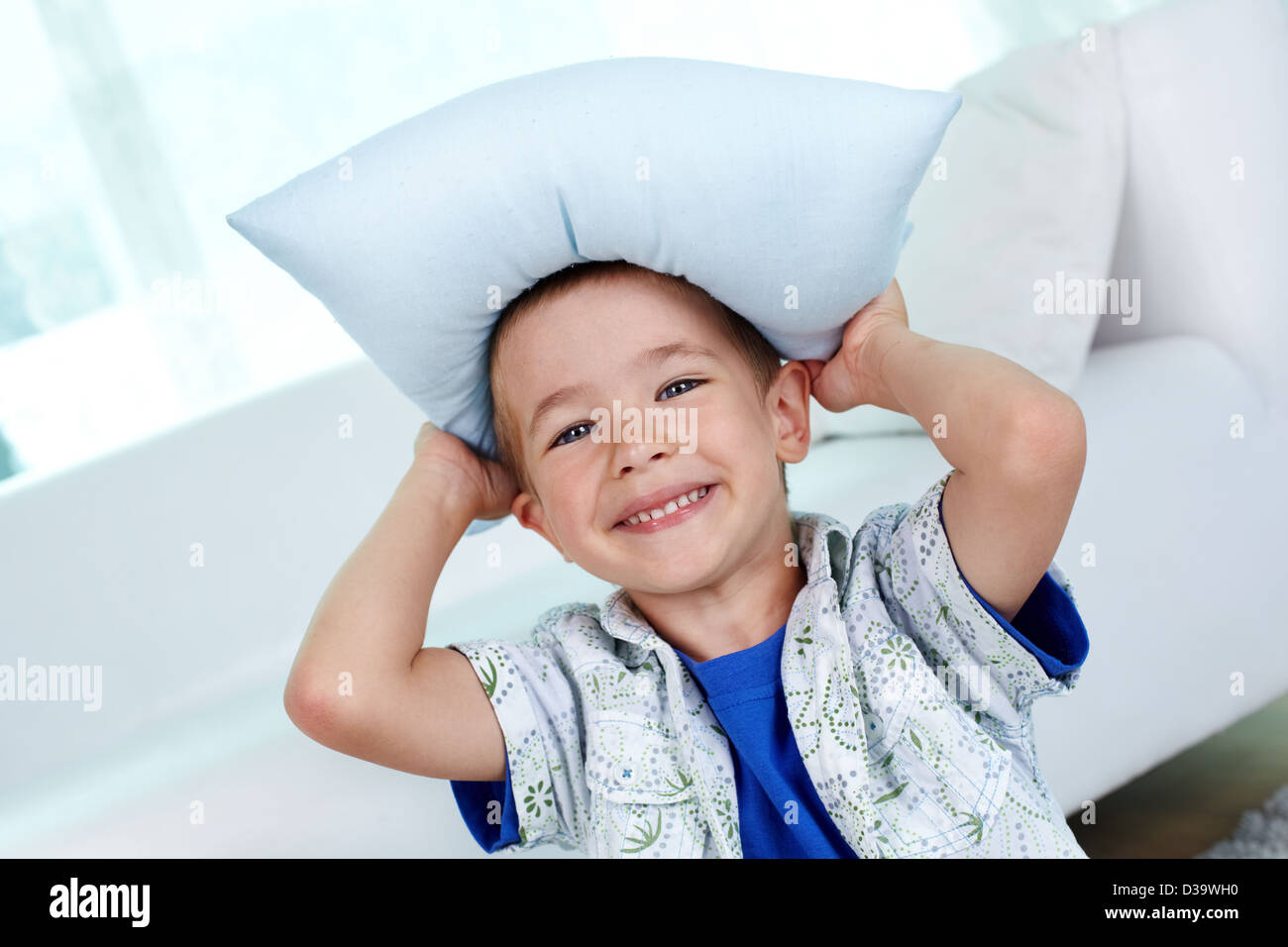 Playful little boy wearing a pillow as a hat Stock Photo - Alamy
