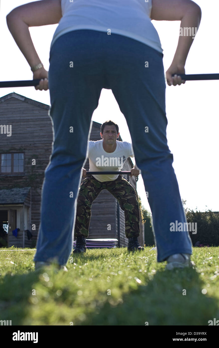 Fitness instructor leading weight lifting class at luxury boot camp ...