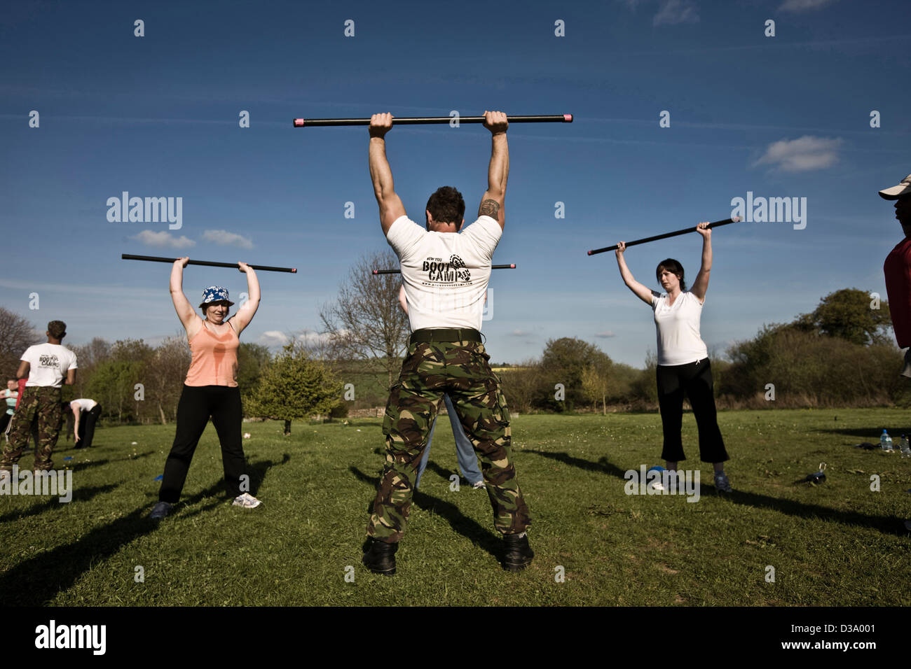 Fitness instructor leading weight lifting class at luxury boot camp ...