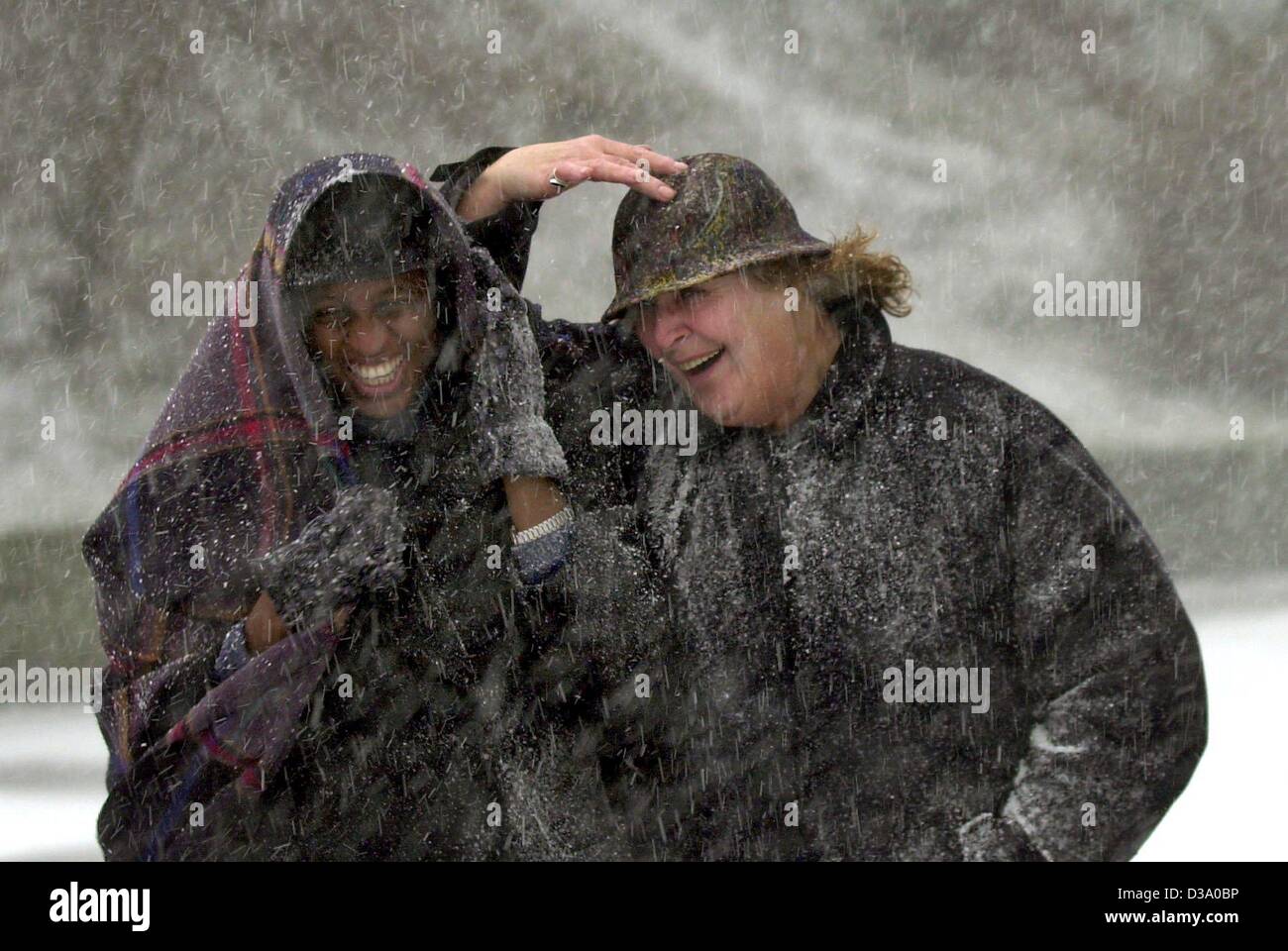 (dpa) - Two women are laughing despite the nasty weather on a winter ...