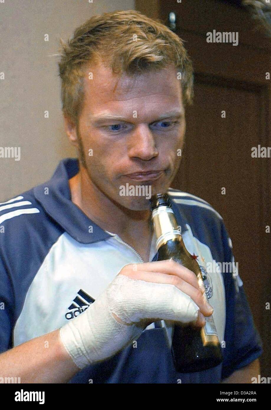 (dpa) - Sad German goalkeeper Oliver Kahn drinks thoughtfully a beer ...