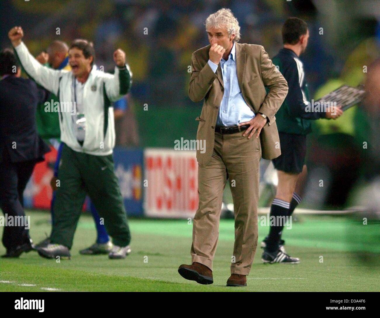 (dpa) - German coach Rudi Voeller walks sadly across the green while ...