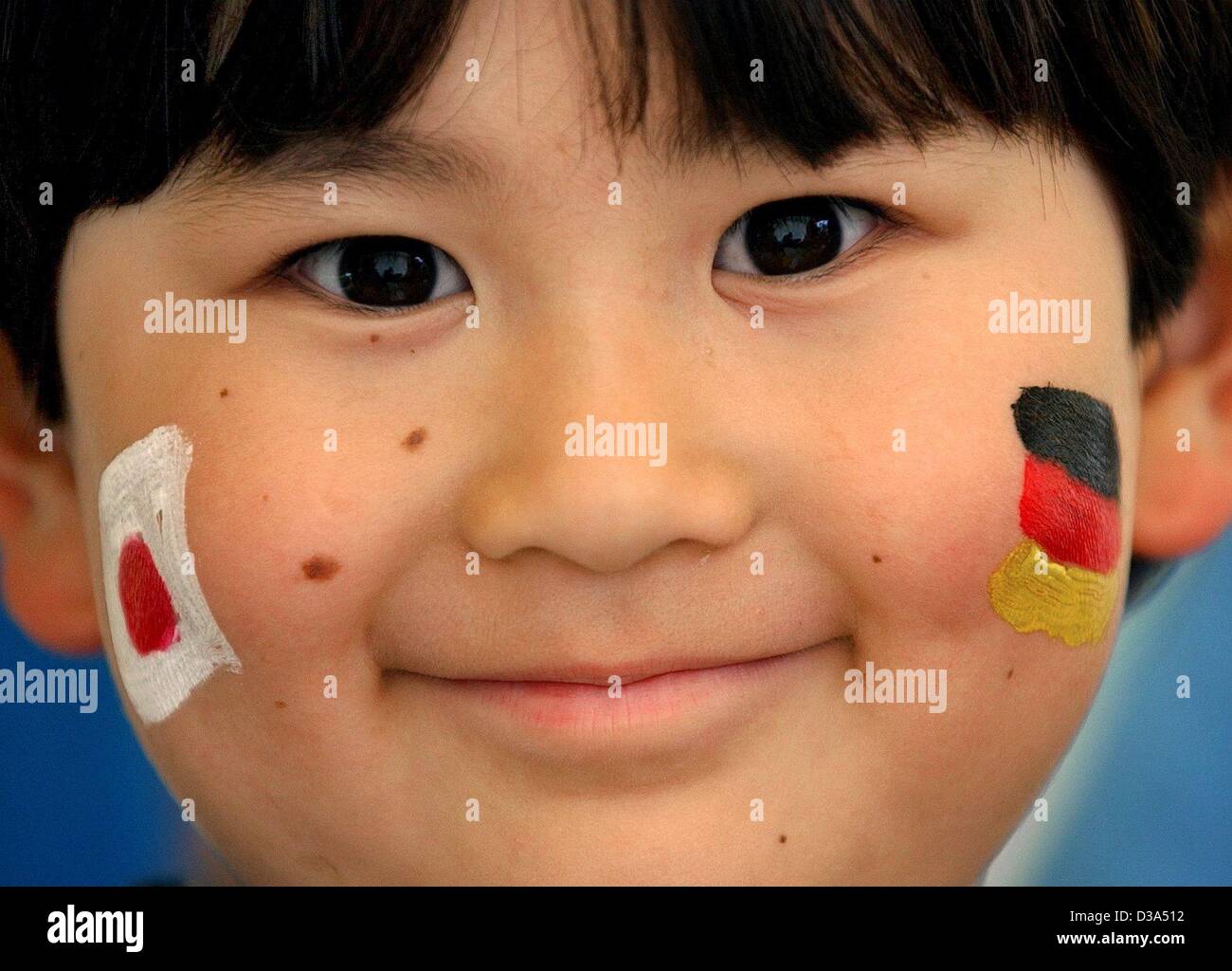 (dpa) - A young boy who has the German and Japanese flags painted in ...