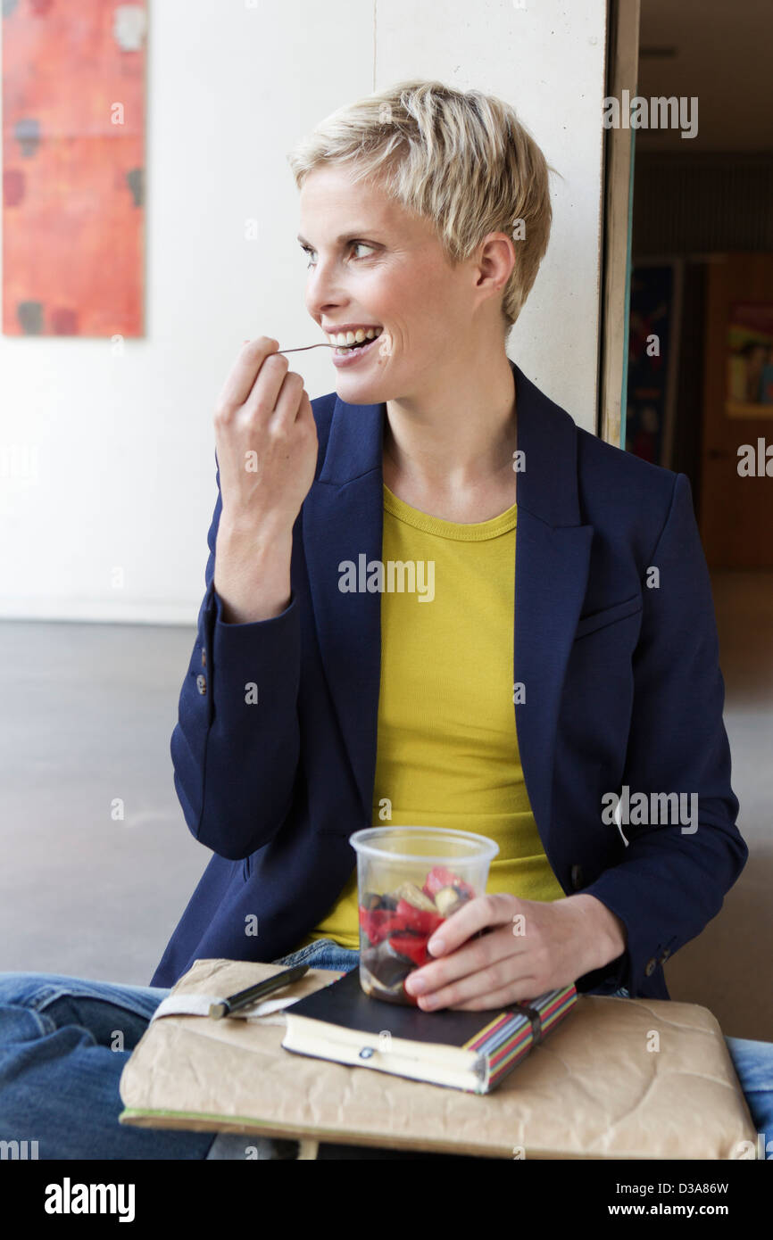 Smiling woman eating salad Stock Photo - Alamy