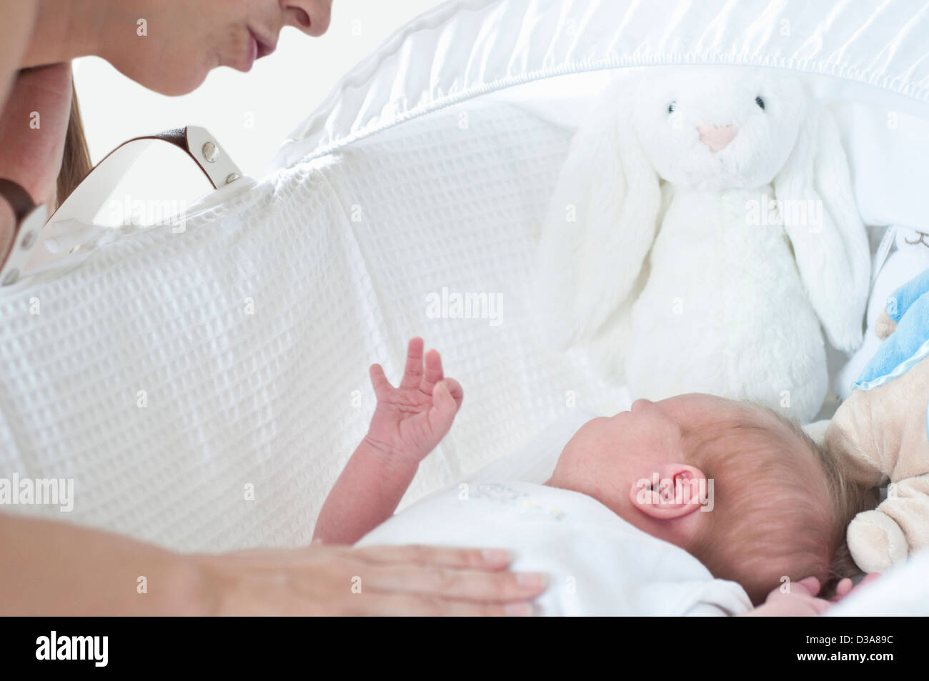Mother comforting infant son in crib Stock Photo - Alamy