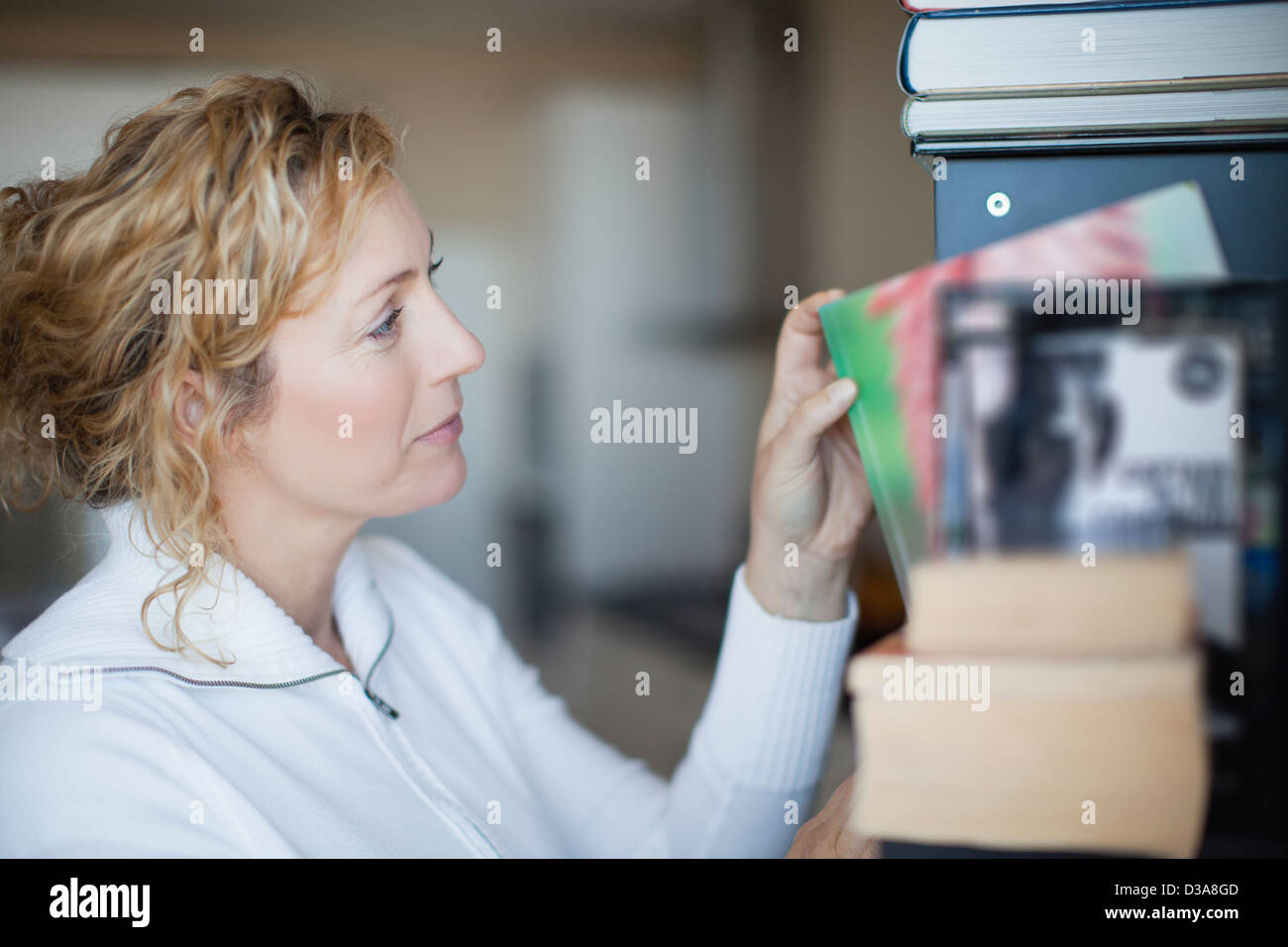Woman organizing bookshelf Stock Photo - Alamy