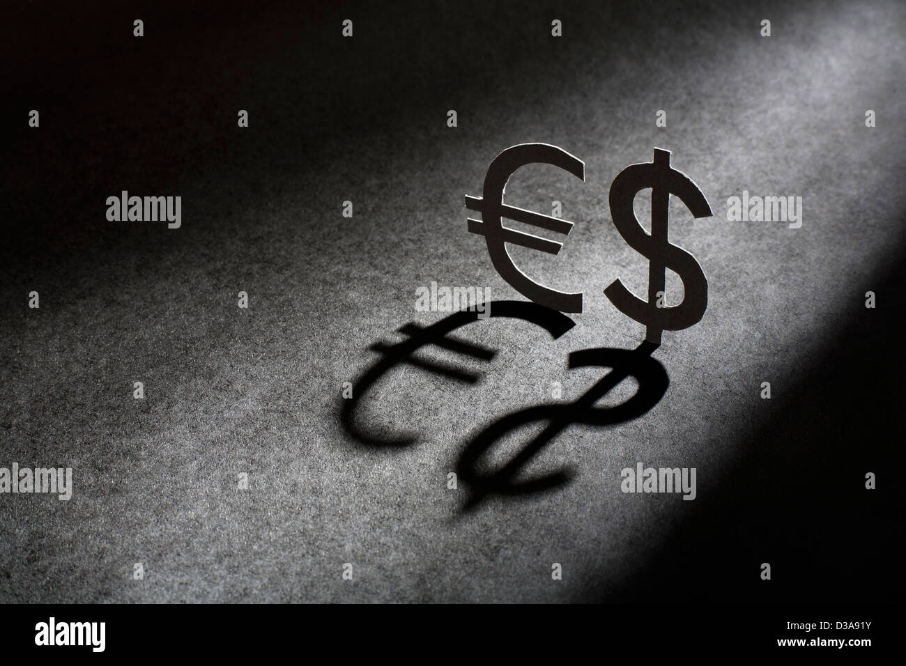 Metal currency signs casting shadow Stock Photo - Alamy