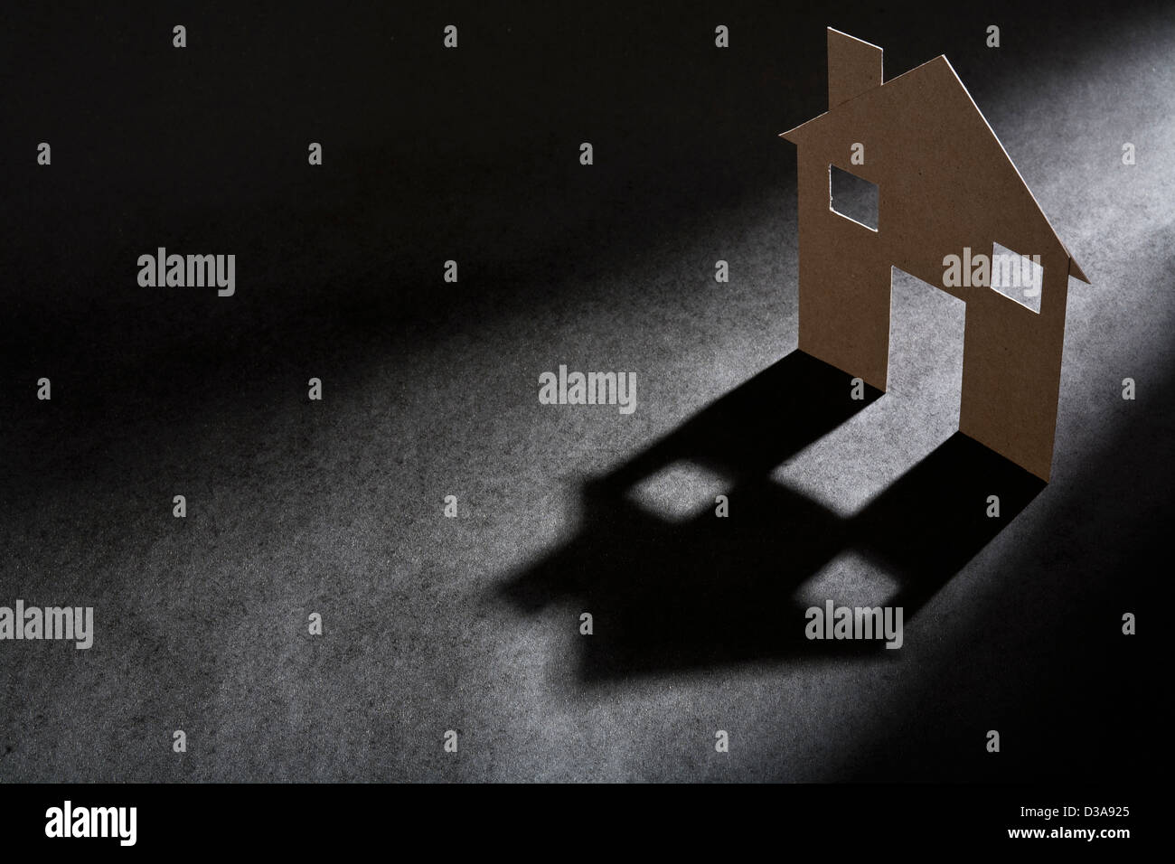 Cardboard house shape casting shadow Stock Photo - Alamy