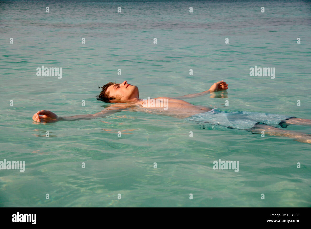Man floating in tropical water Stock Photo - Alamy
