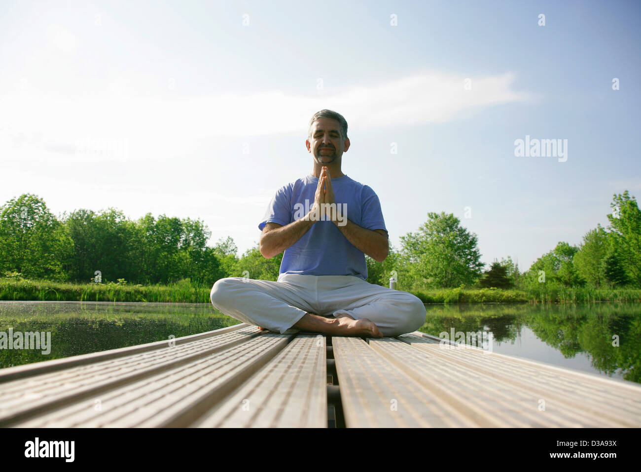 Man meditating on wooden pier Stock Photo - Alamy