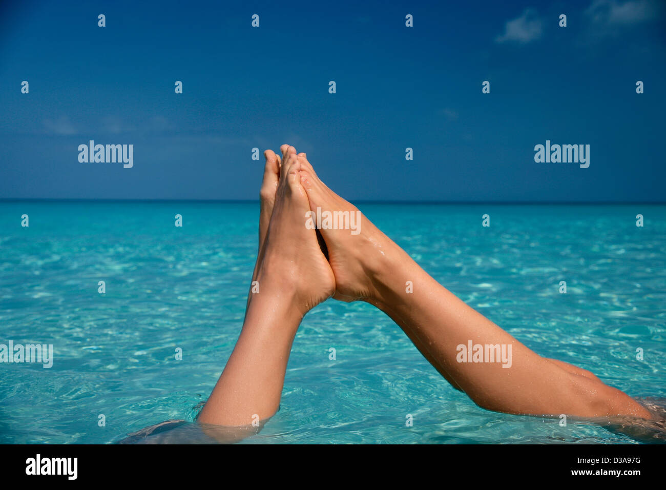 Feet touching in tropical water Stock Photo - Alamy