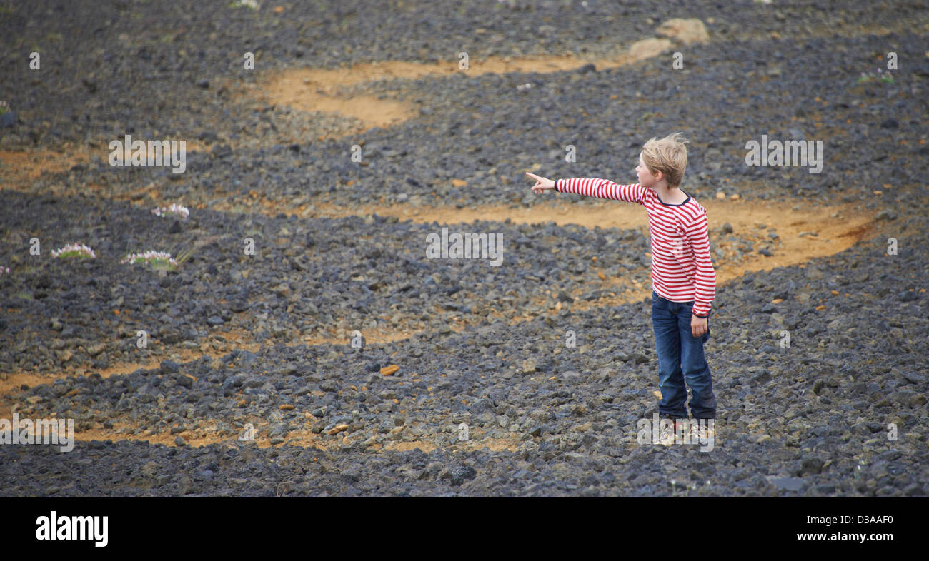 Girl pointing in rocky landscape Stock Photo - Alamy