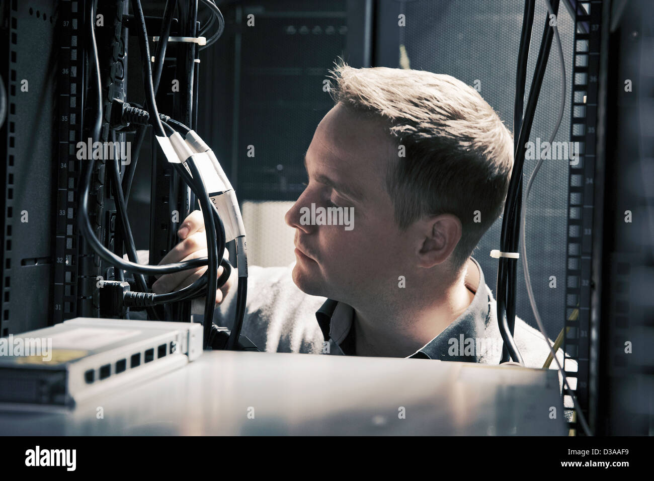 Man working in server room Stock Photo - Alamy