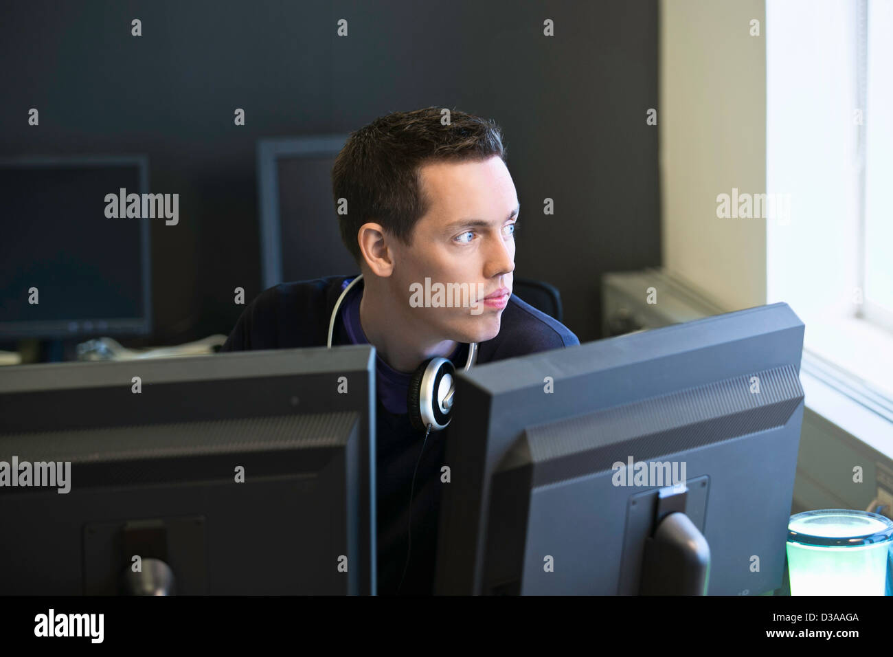 Man using computers at desk Stock Photo - Alamy