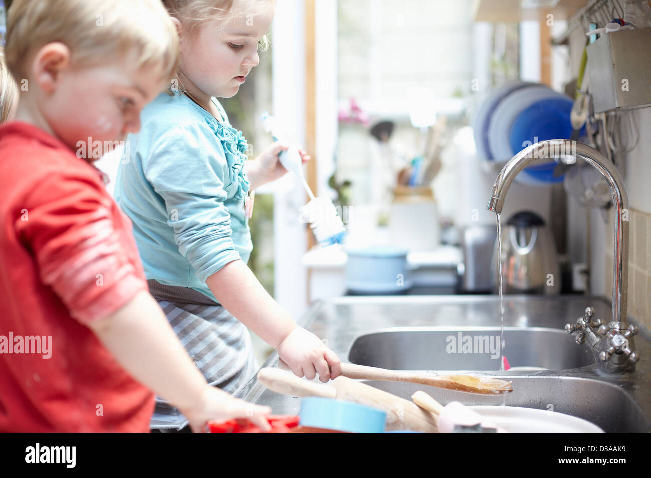 Children washing dishes together Stock Photo - Alamy