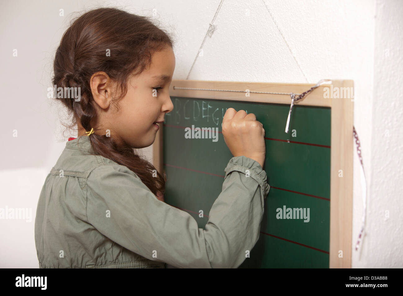 Girl writing on small chalkboard Stock Photo - Alamy