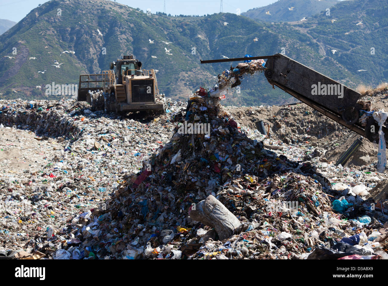 Machinery dumping waste in landfill Stock Photo - Alamy