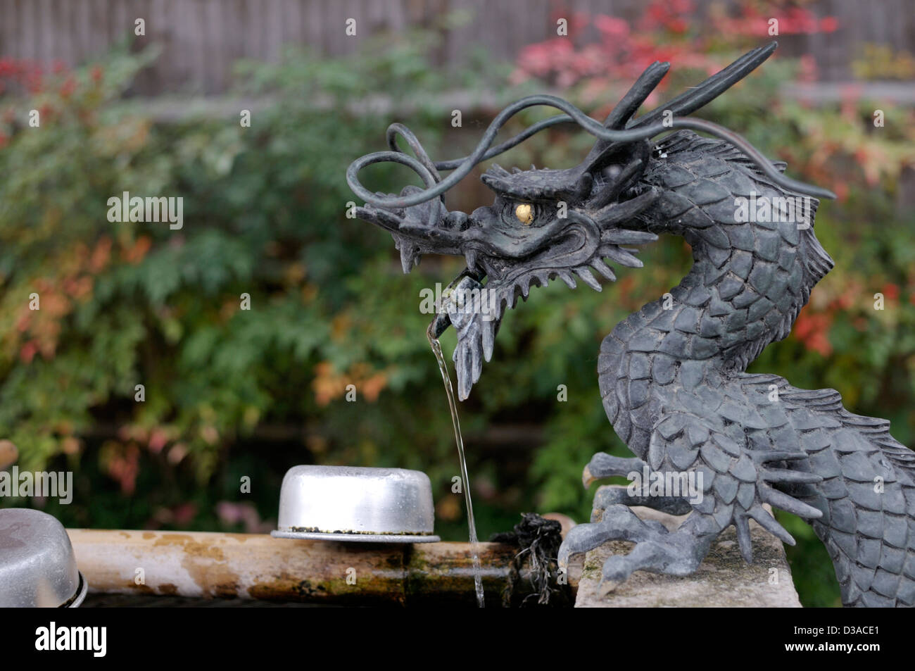 A traditional guardian statue, a dragon, in a temple garden Stock Photo ...