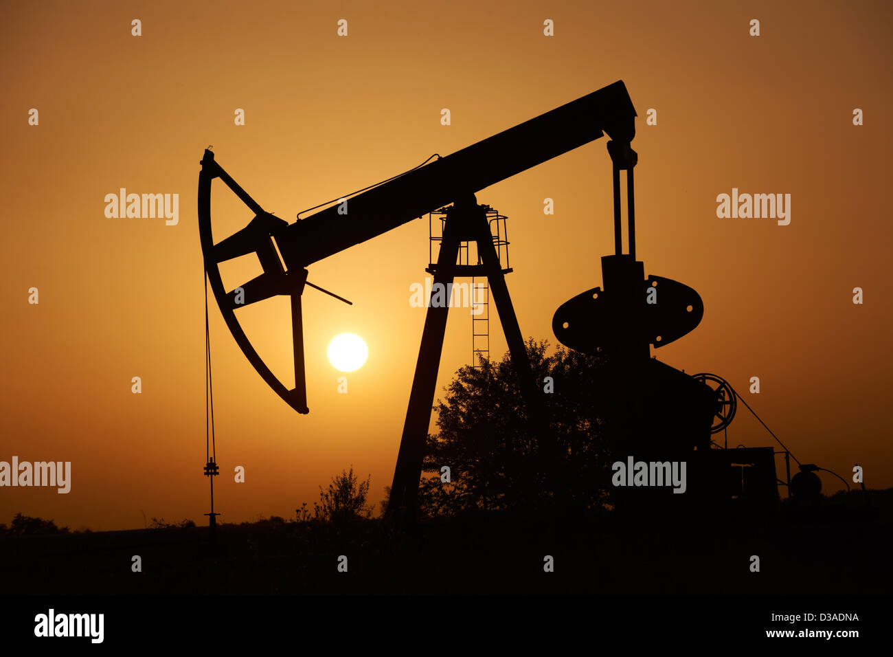 Oil pump silhuette and the Sun at sunset Stock Photo - Alamy