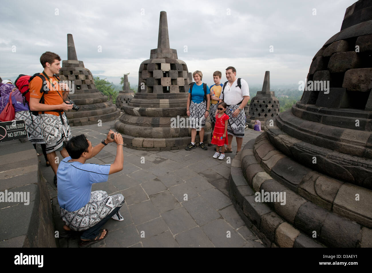 A group of tourists have their photo taken at the Borobudur Buddhist ...