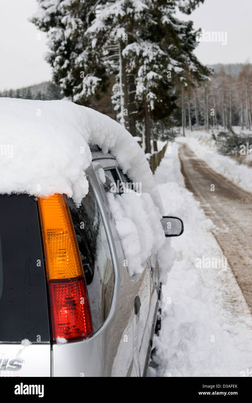 A snow covered car on a passable rural road in Aberdeenshire Stock ...