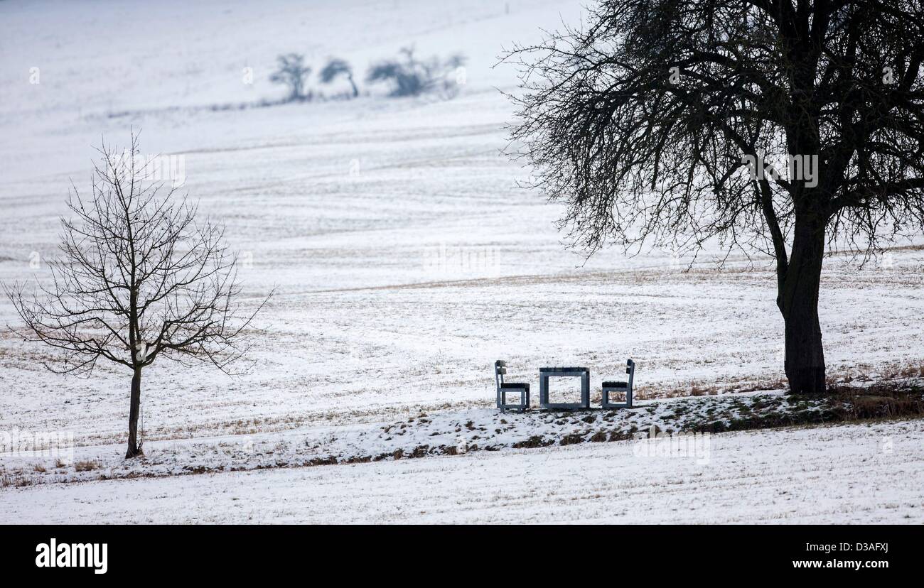 A bench sits between trees in a snow-covered field in Belrieth, Germany ...