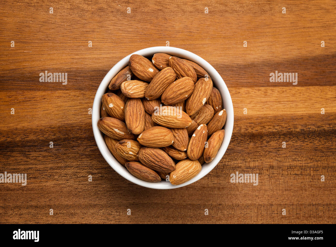 roasted almonds in white porcelain bowl, food background Stock Photo ...