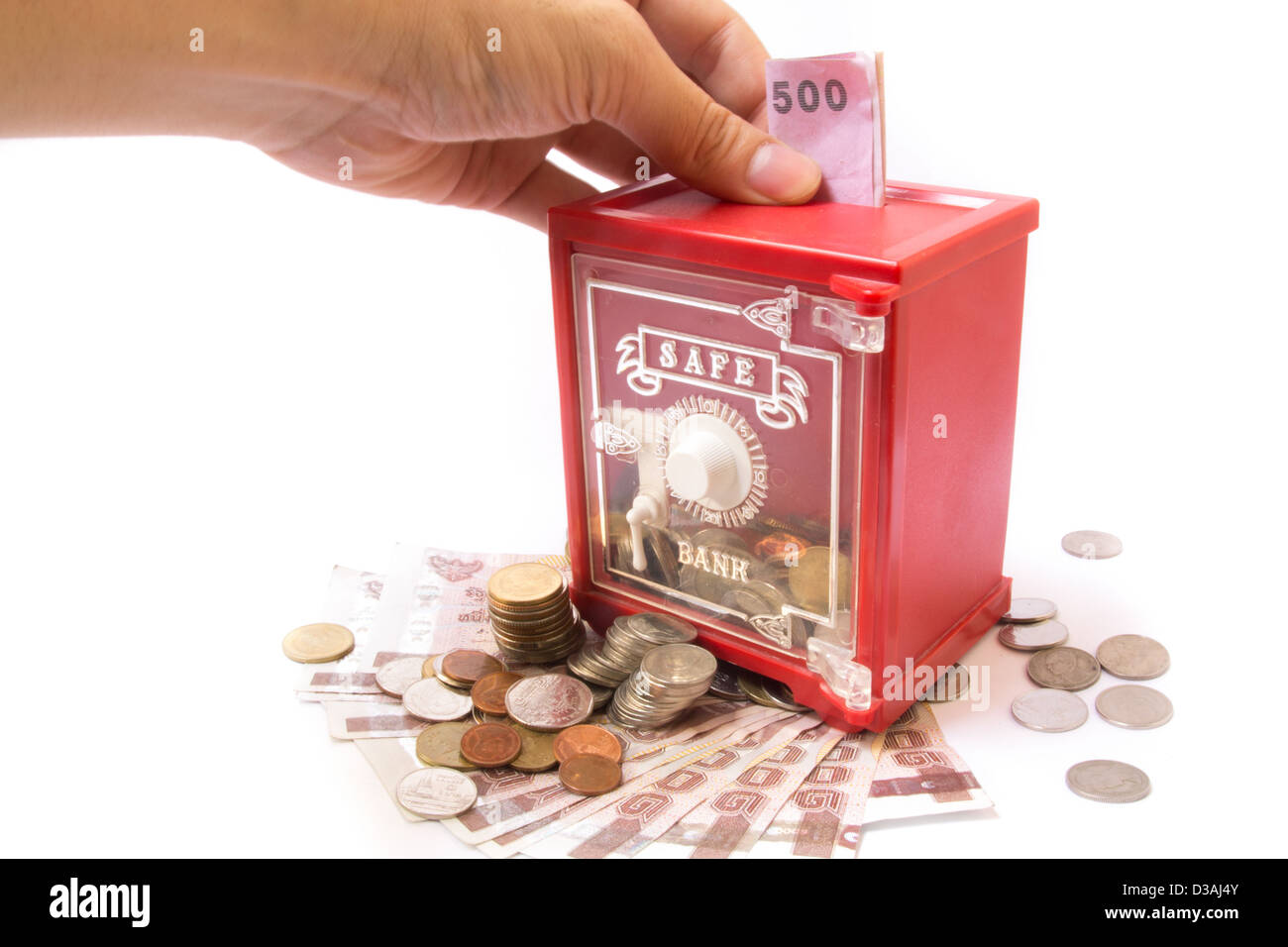 Saving, male hand putting a coin into safe bank Stock Photo - Alamy