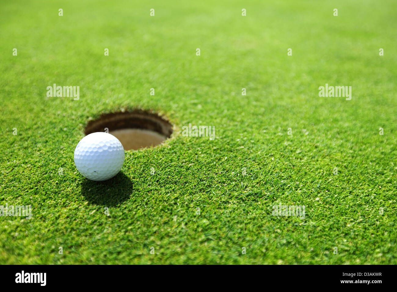 golf ball on lip of cup Stock Photo - Alamy