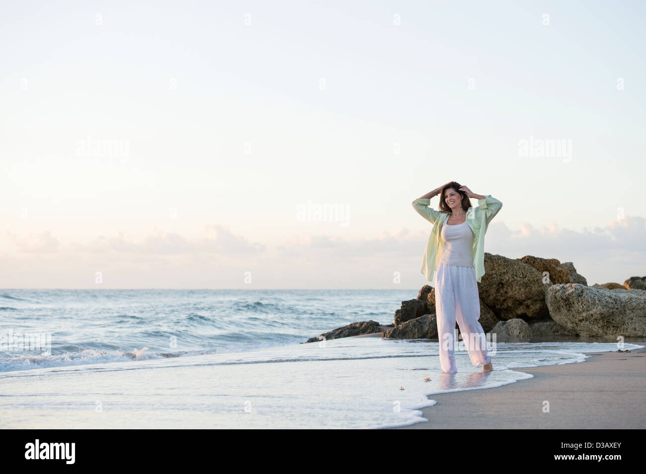 Caucasian woman walking on beach Stock Photo - Alamy