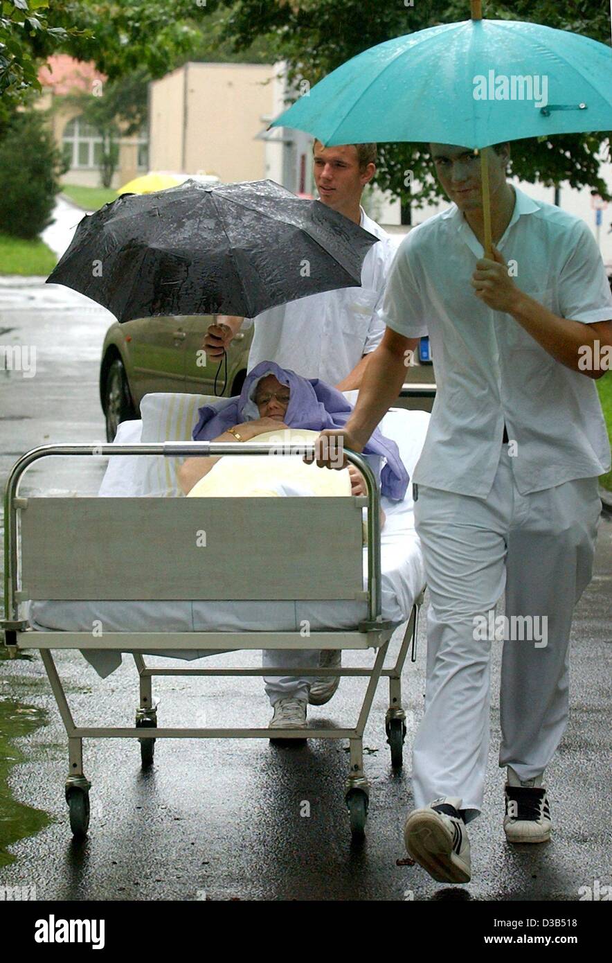 (dpa) - Two medical attendants push their patient in a bed through the ...