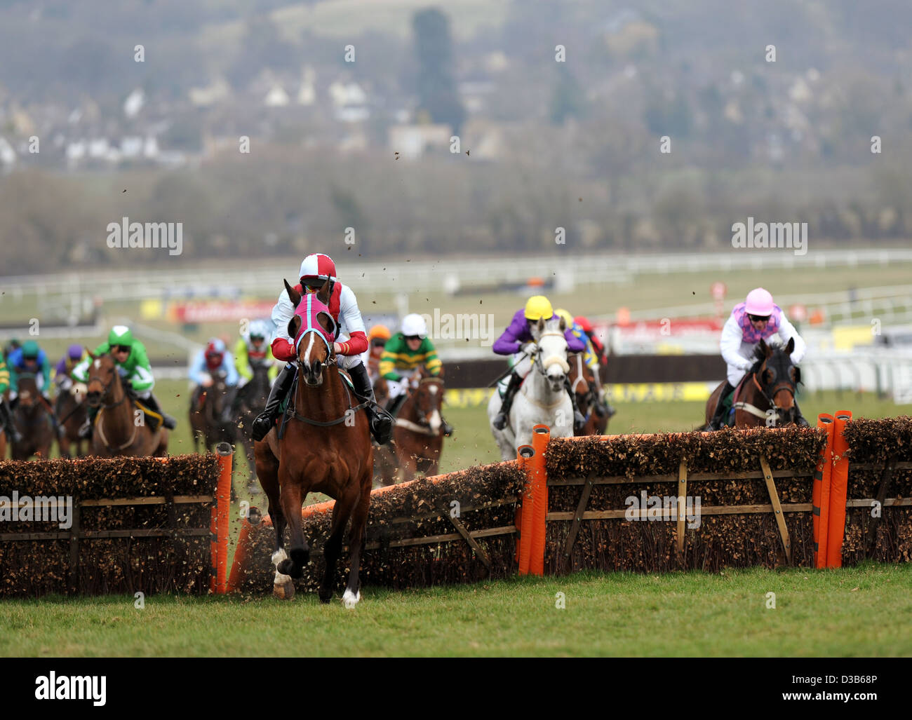 Jockeys jump their horses over a fence during The Cheltenham Festival ...