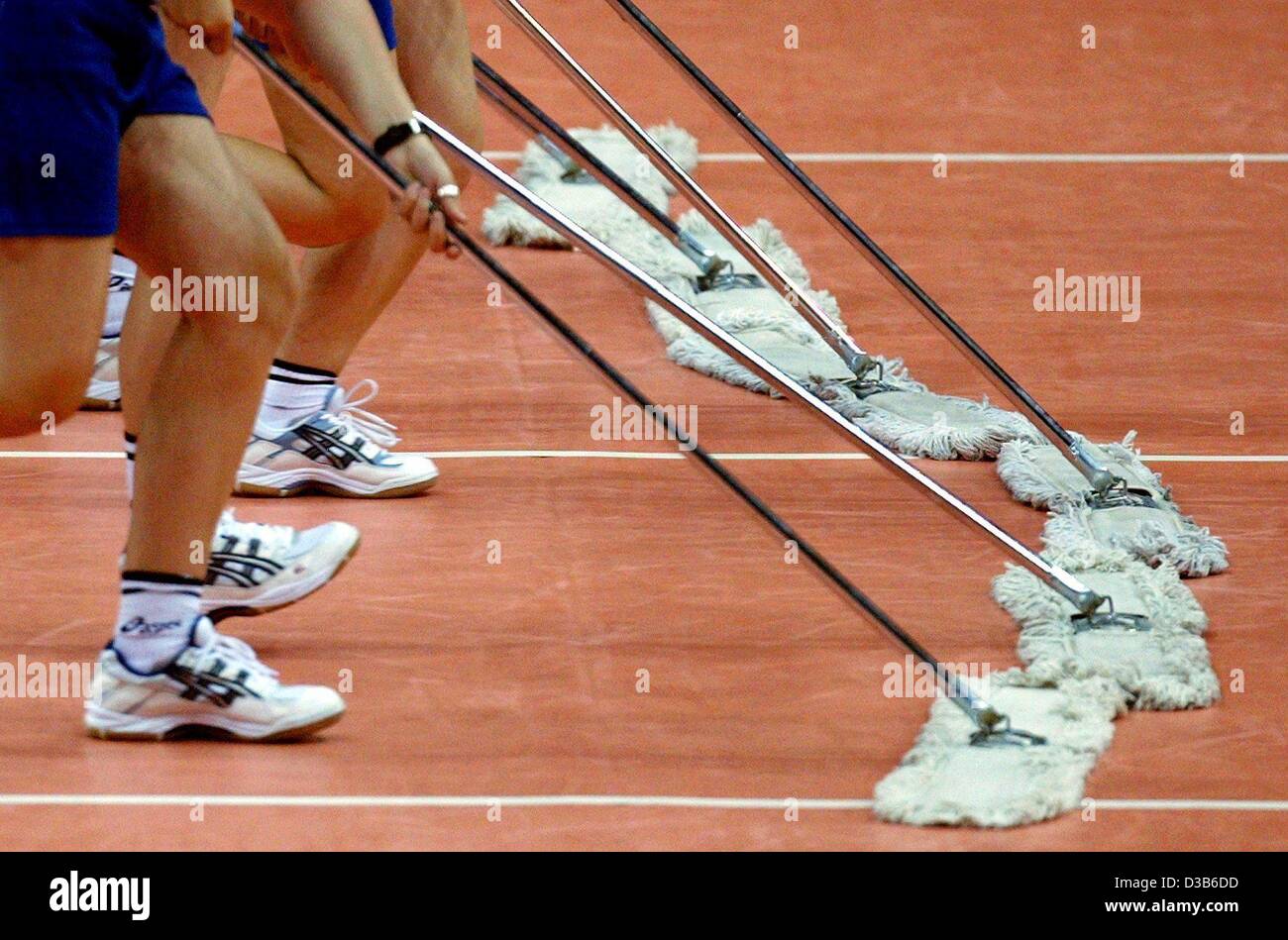 (dpa) - Busy sweepers mop the floor of the gym during a break in the ...