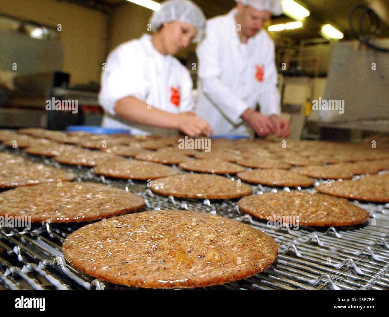 (dpa) - Workers produce gingerbread at a production line of the company ...