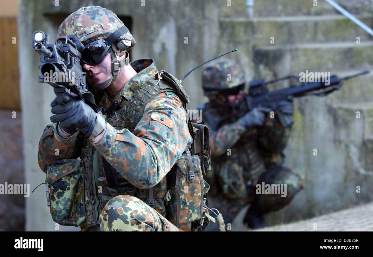 A soldier equipped with hi-tech weapon prototype is aiming at a target ...