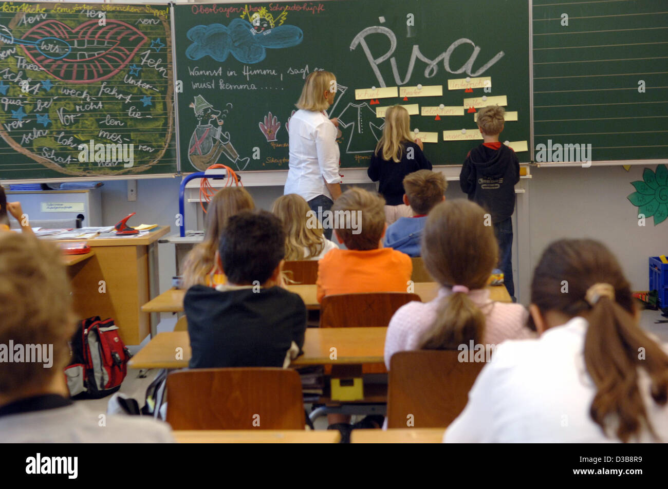 (dpa) - Students of 4th grade work with their teacher on exercises on ...