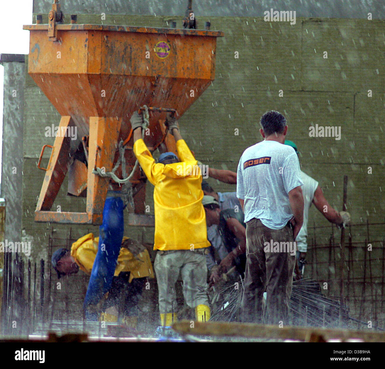 (dpa) - The picture shows construction workers in the pouring rain at a ...