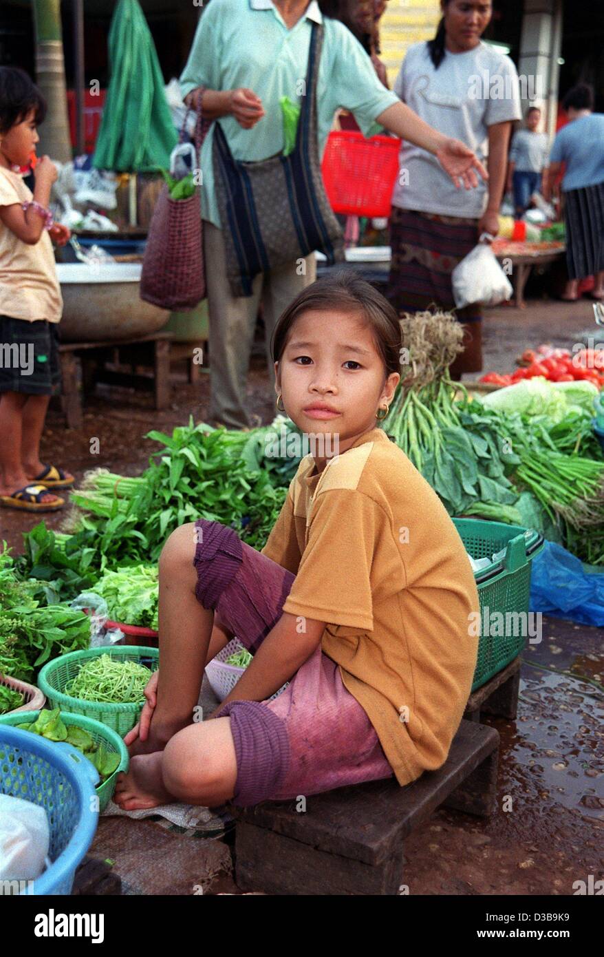(dpa) - A little girl sells fresh vegetables on the market in ...