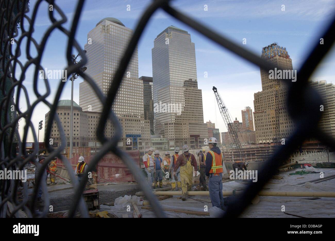 (dpa) - Construction workers behind a fence continue their work at the ...