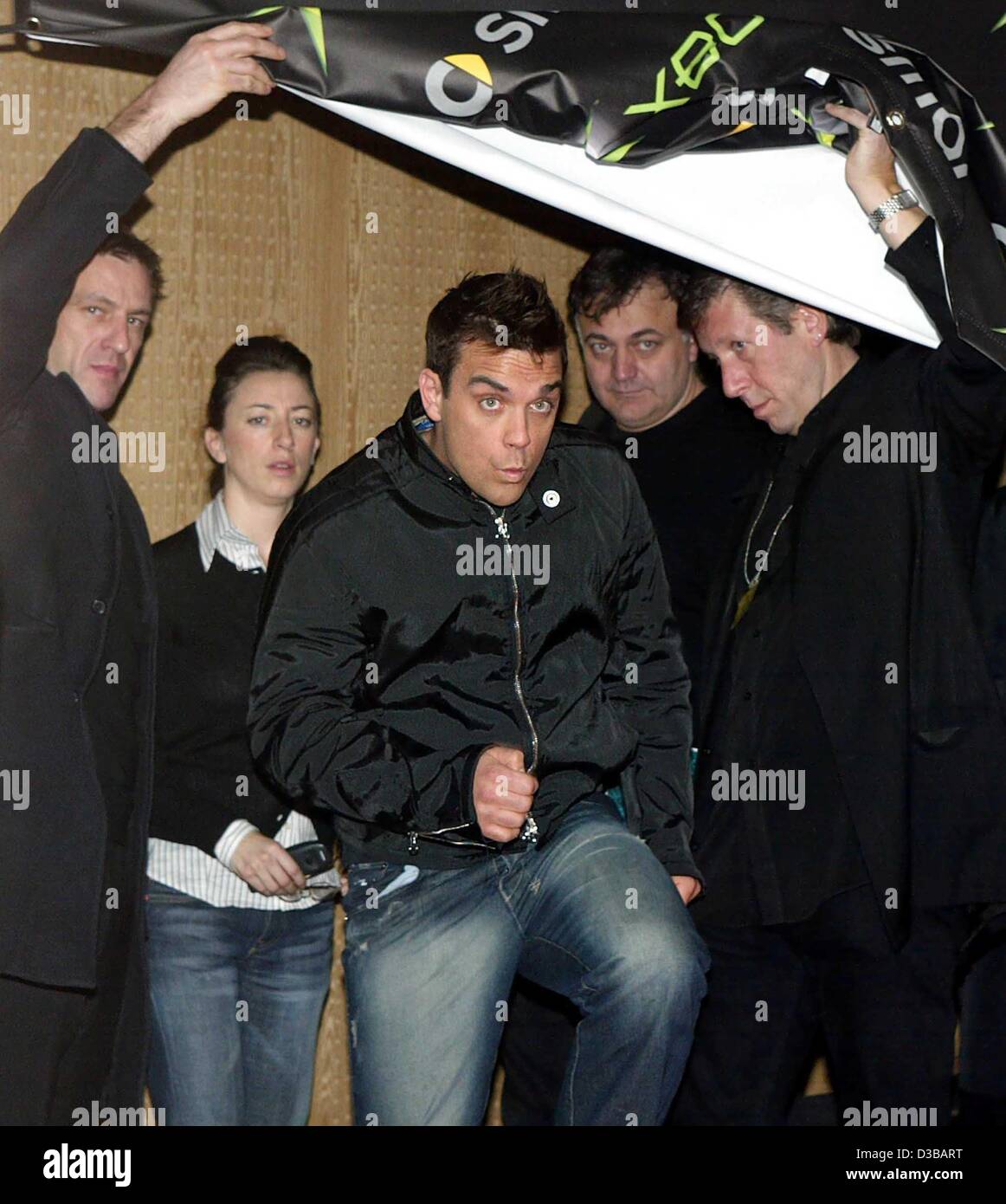 (dpa) - British pop singer Robbie Williams (C) arrives at a press ...