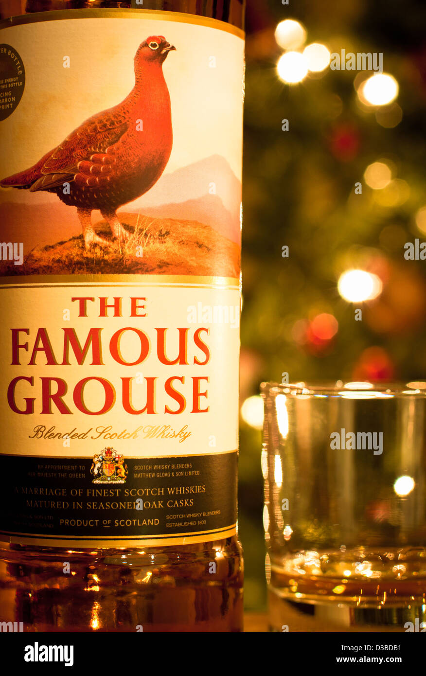 A bottle of Grouse Scottish Whiskey next to a tumbler of whiskey Stock ...