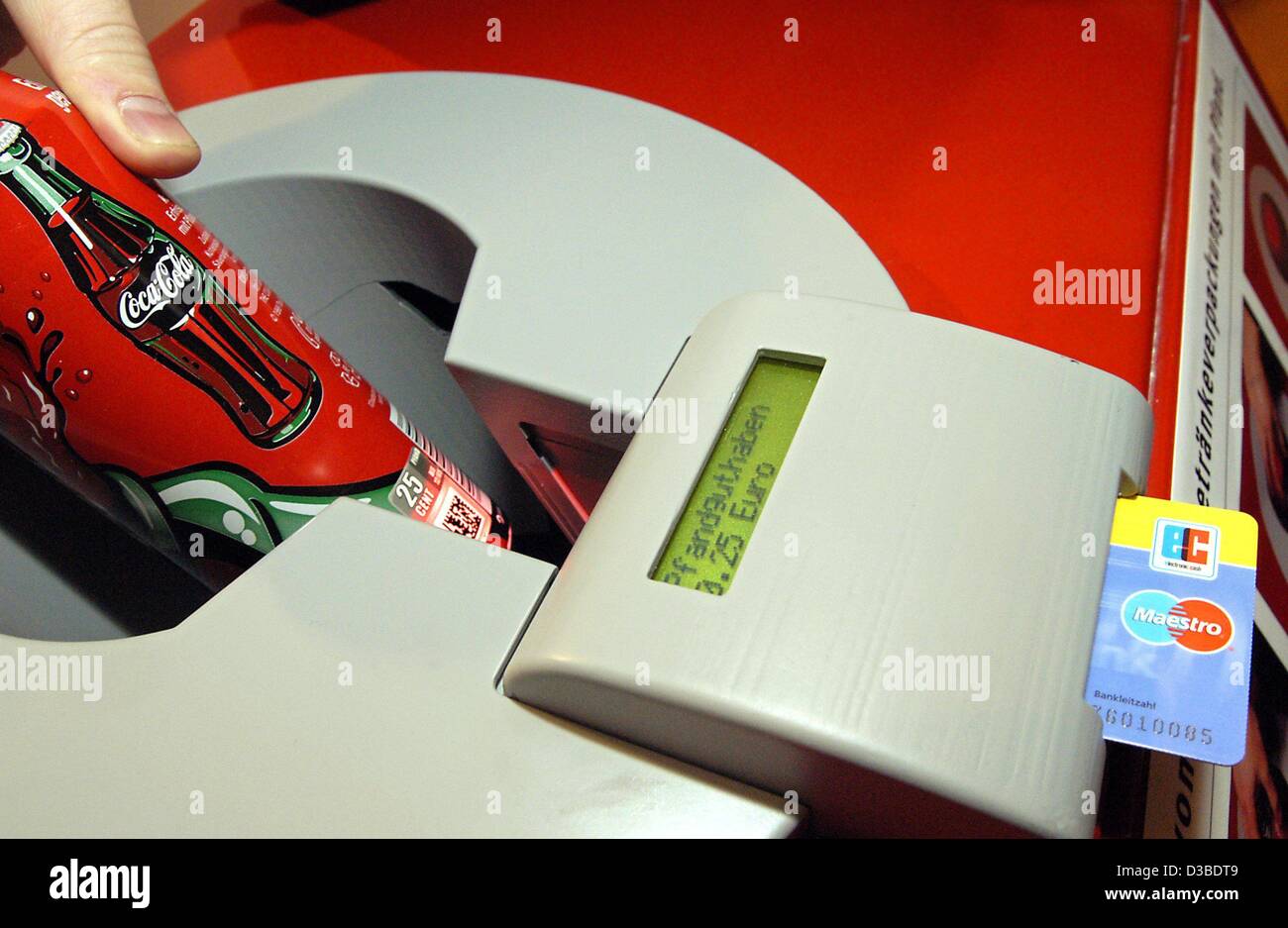(dpa) - An employee puts an empty coke can into the slot of a new ...