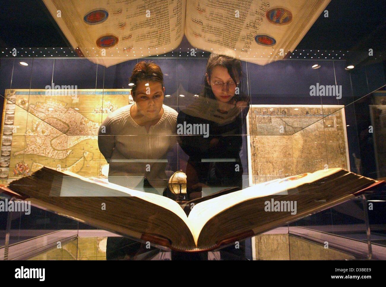 (dpa) - Two visitors look at a vintage book exhibited in the book ...