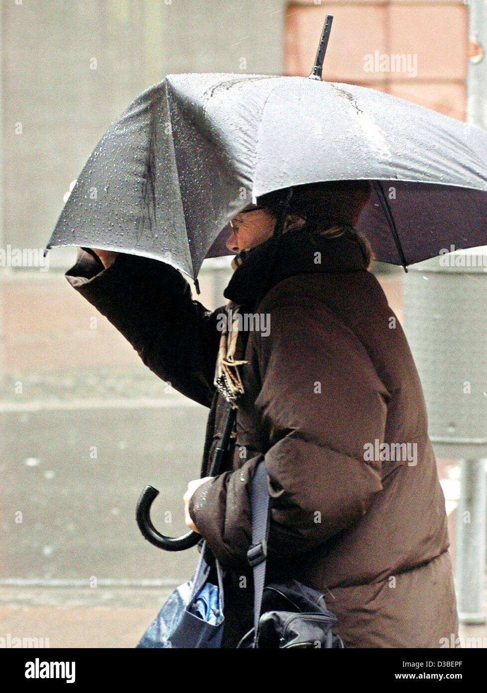 (dpa) - The passer-by is battling against wind and rain in downtown ...