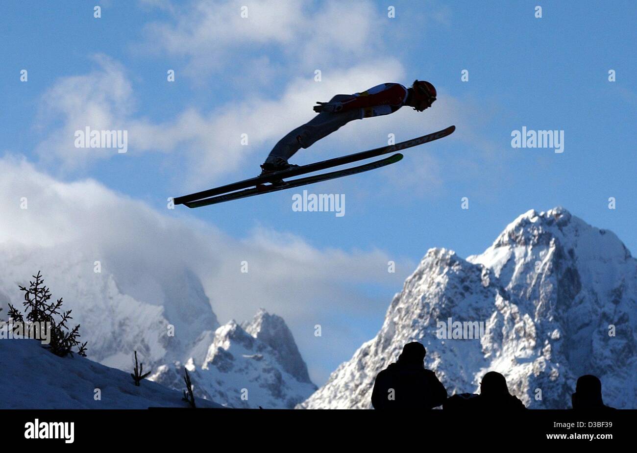 (dpa) - A ski jumper flies through the air in front of a panoramic view ...