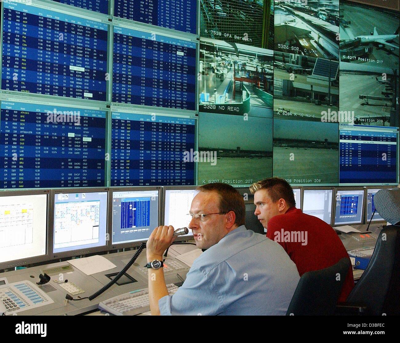 (dpa) - Two employees sit in front of computer screens and monitors and ...